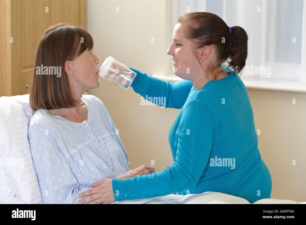 Helping a person to drink Stock Photo - Alamy