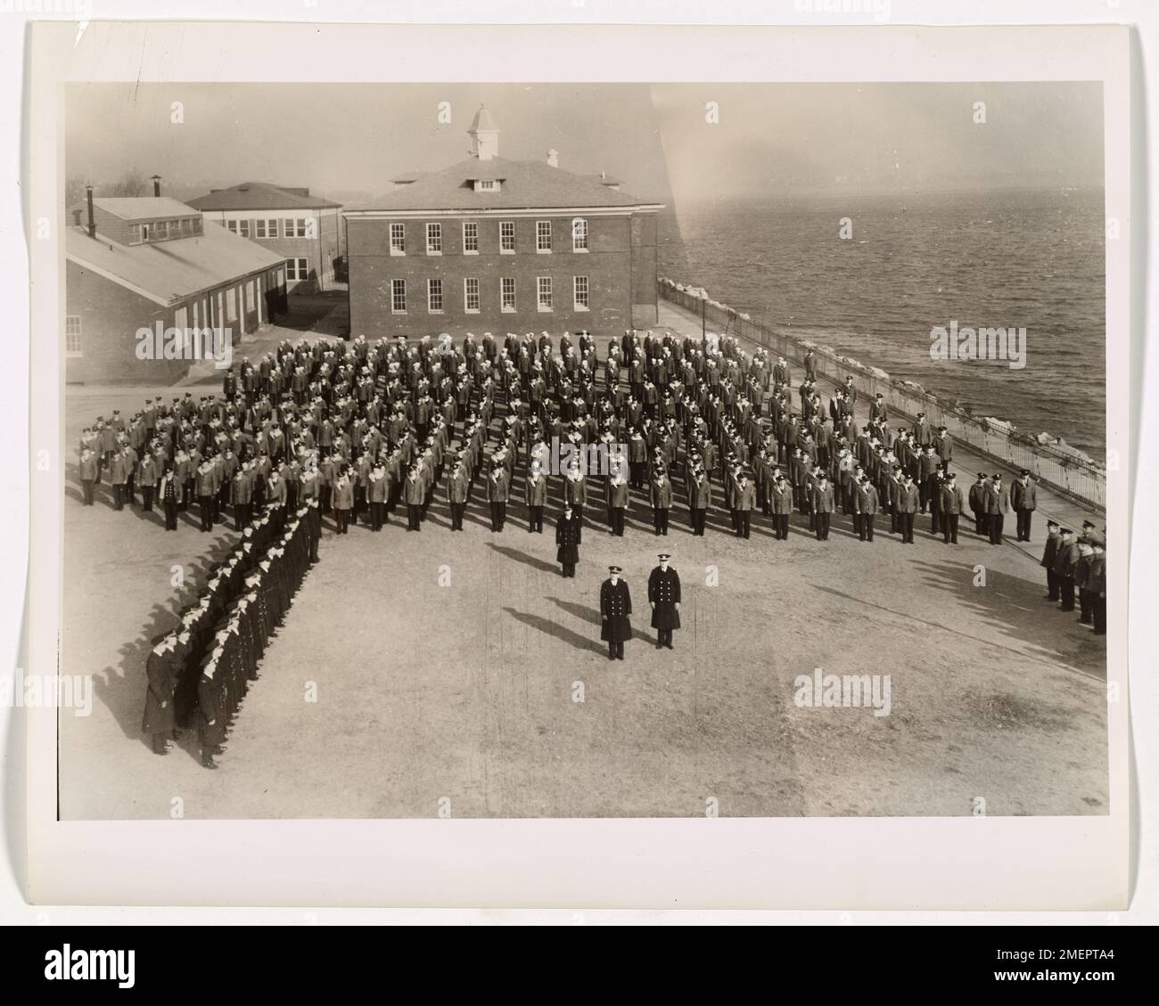 Aerial photograph showing a group of enrollees lined up outside a ...