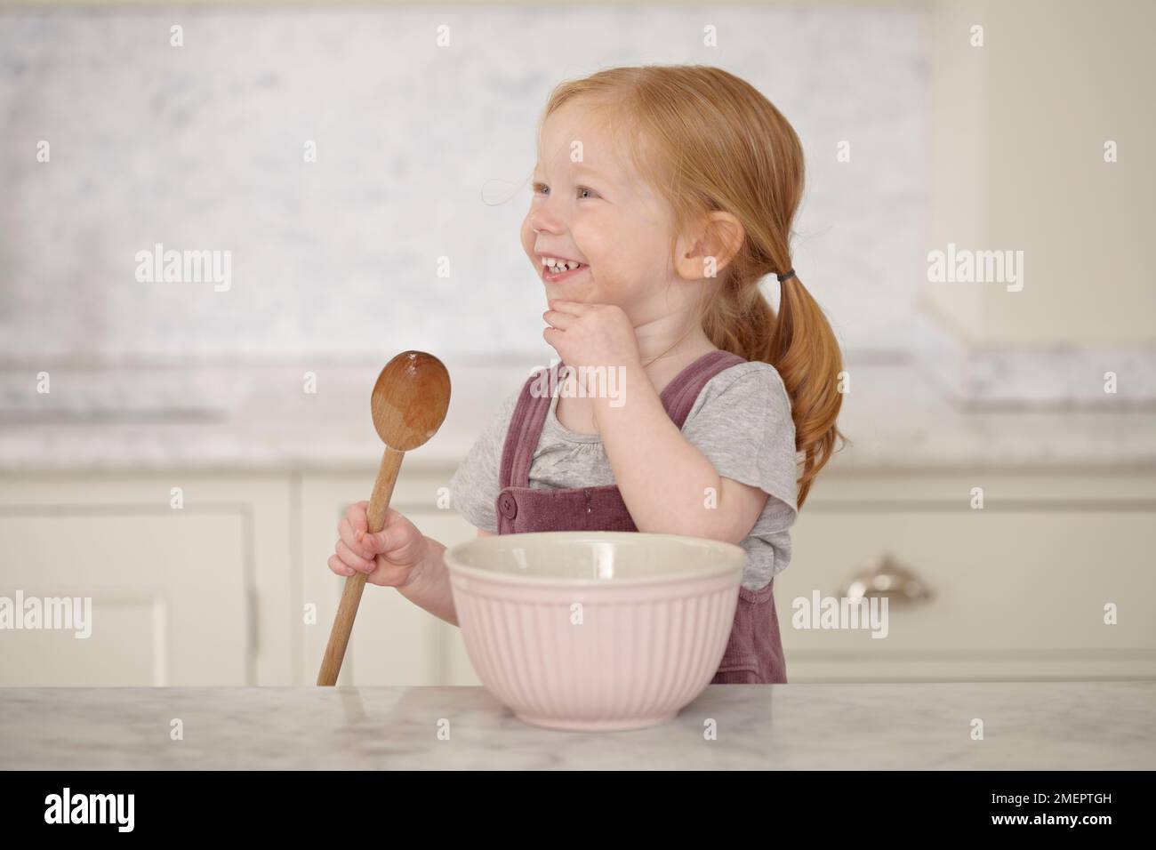 Small girl holding wooden spoon and mixing bowl, 2 years Stock Photo ...