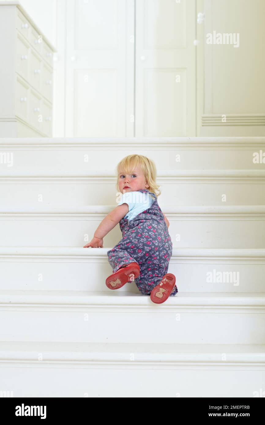 Girl crawling up stairs, 18 months Stock Photo - Alamy