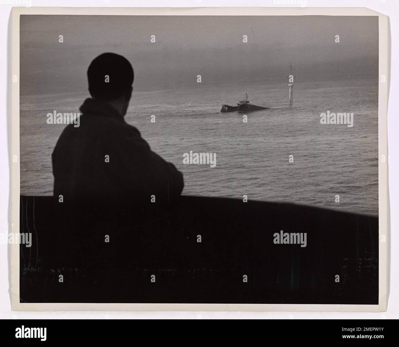 The mast of a sunken vessel protrudes above the sea, reminding a Coast ...