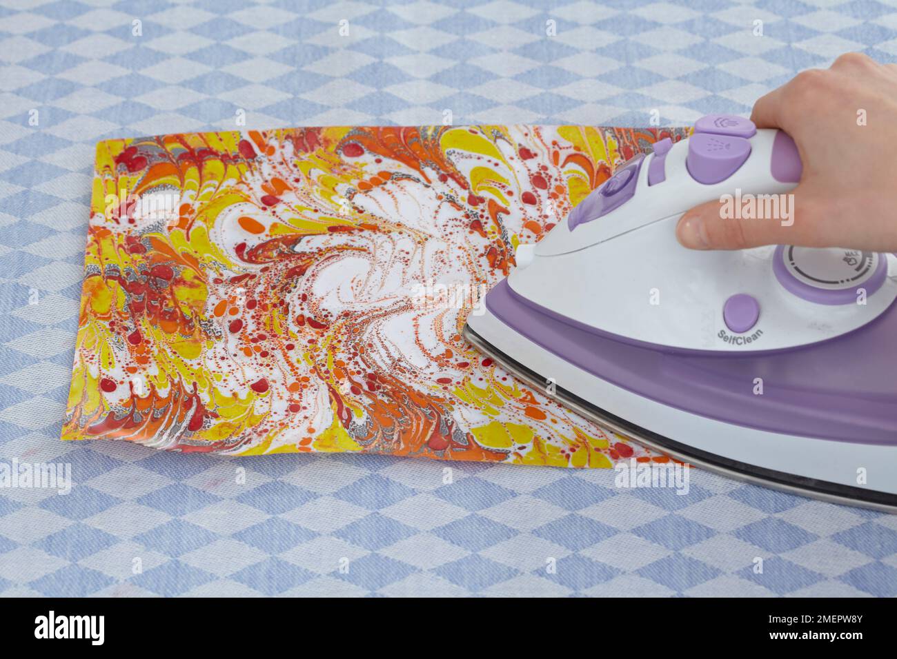Ironing marbled paper face up to flatten out, close-up Stock Photo - Alamy