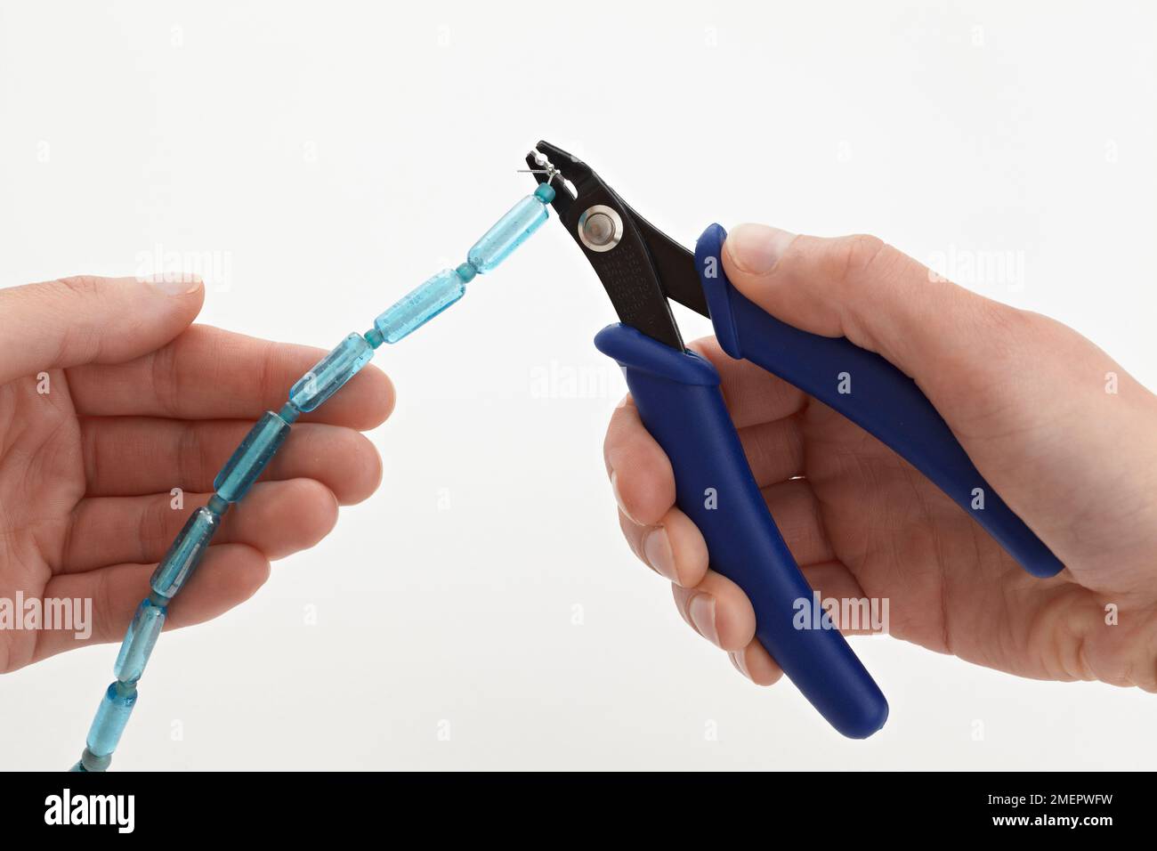 Placing crimp in inner notch of pair of crimping pliers at end of ...