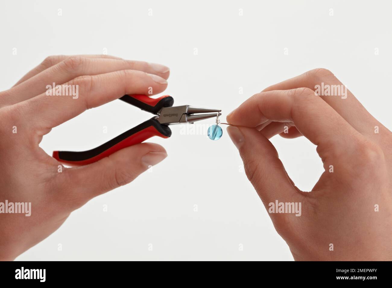 With round-nose pliers through loop to hold piece steady, use fingers ...
