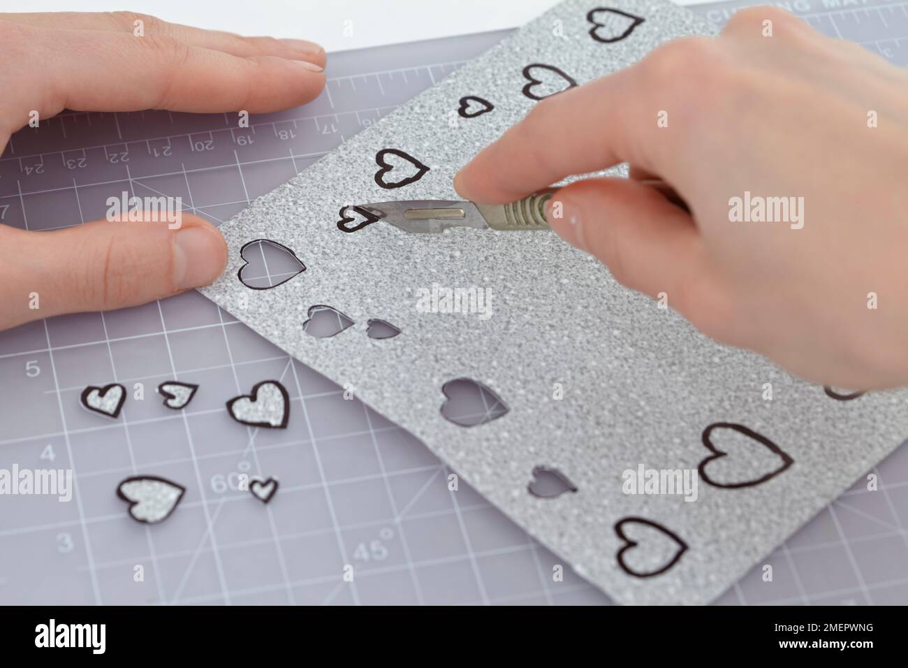 Etching glass, Using scalpel to cut small heart shapes from adhesive ...