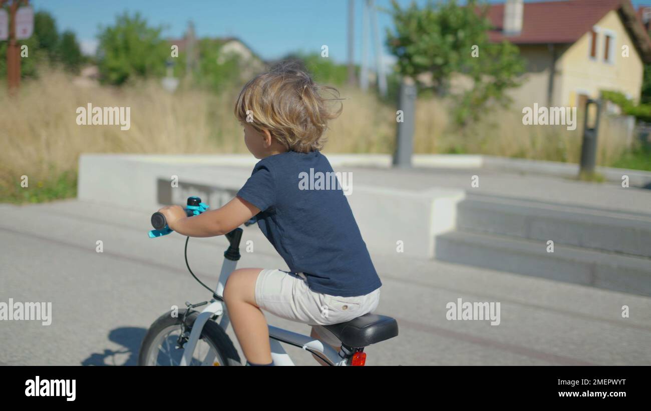 Active little boy riding bicycle outside child rides bike Stock Photo ...