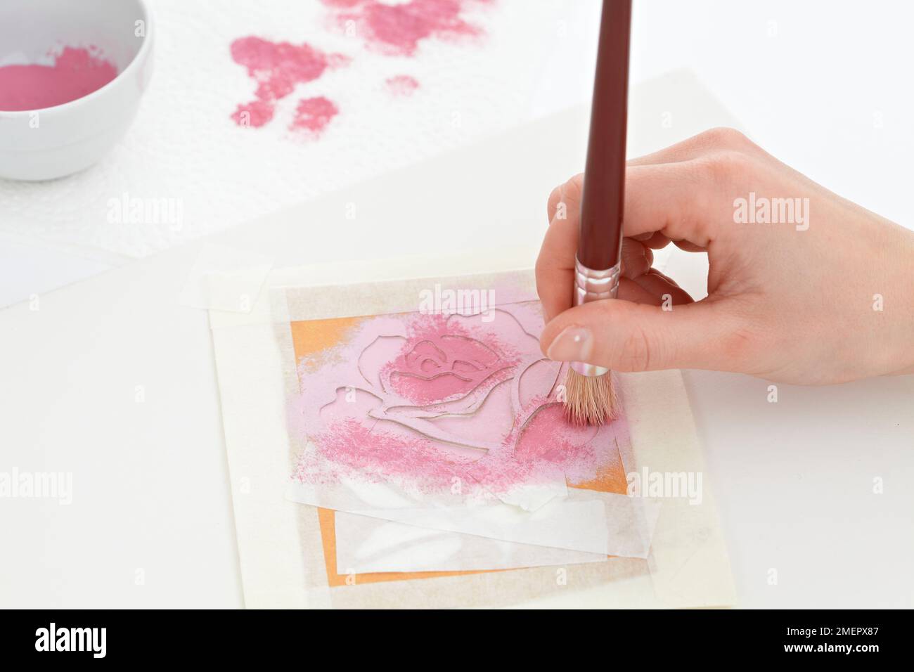 Woman using stencil brush to stipple artists acrylic paint on design ...