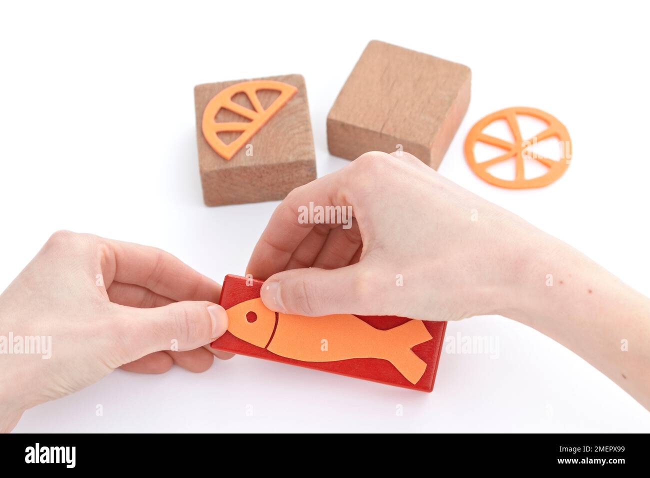 Sticking fish-shaped craft foam to printing block to decorate apron ...