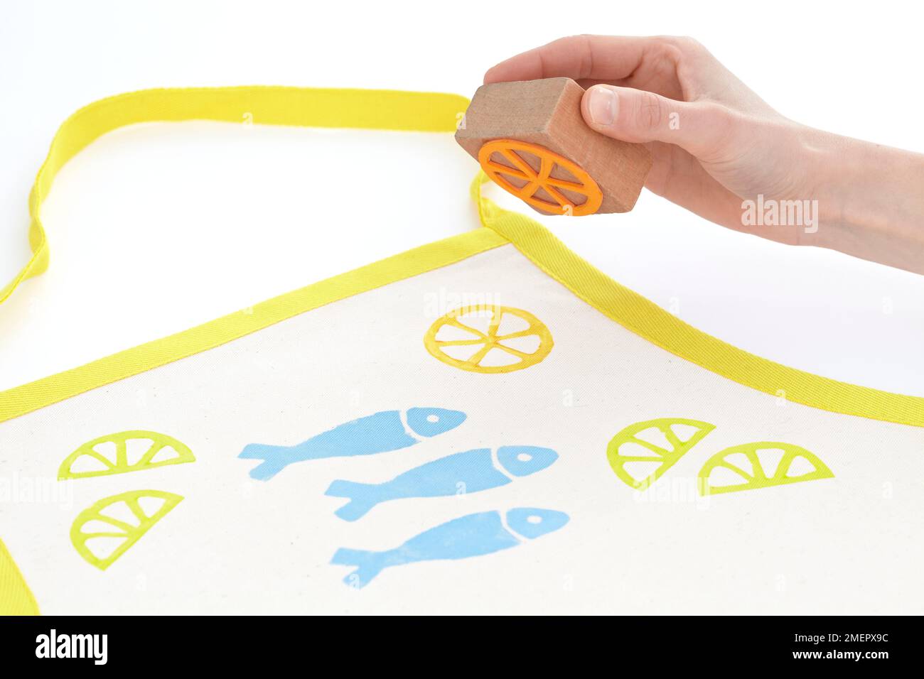 Using sliced orange-shaped craft foam printing block to decorate apron ...
