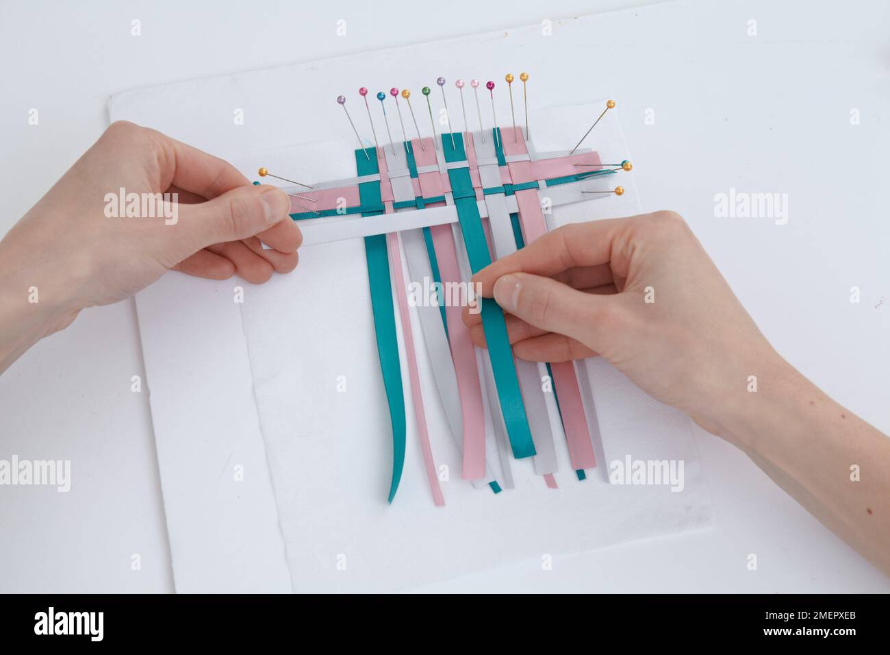 Weaving ribbons lifting alternate vertical ribbons pinned to ...