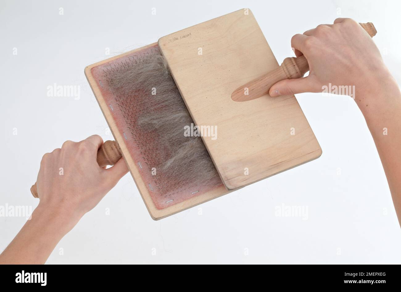 Brushing fleece by holding left carder in hand and pulling right carder ...