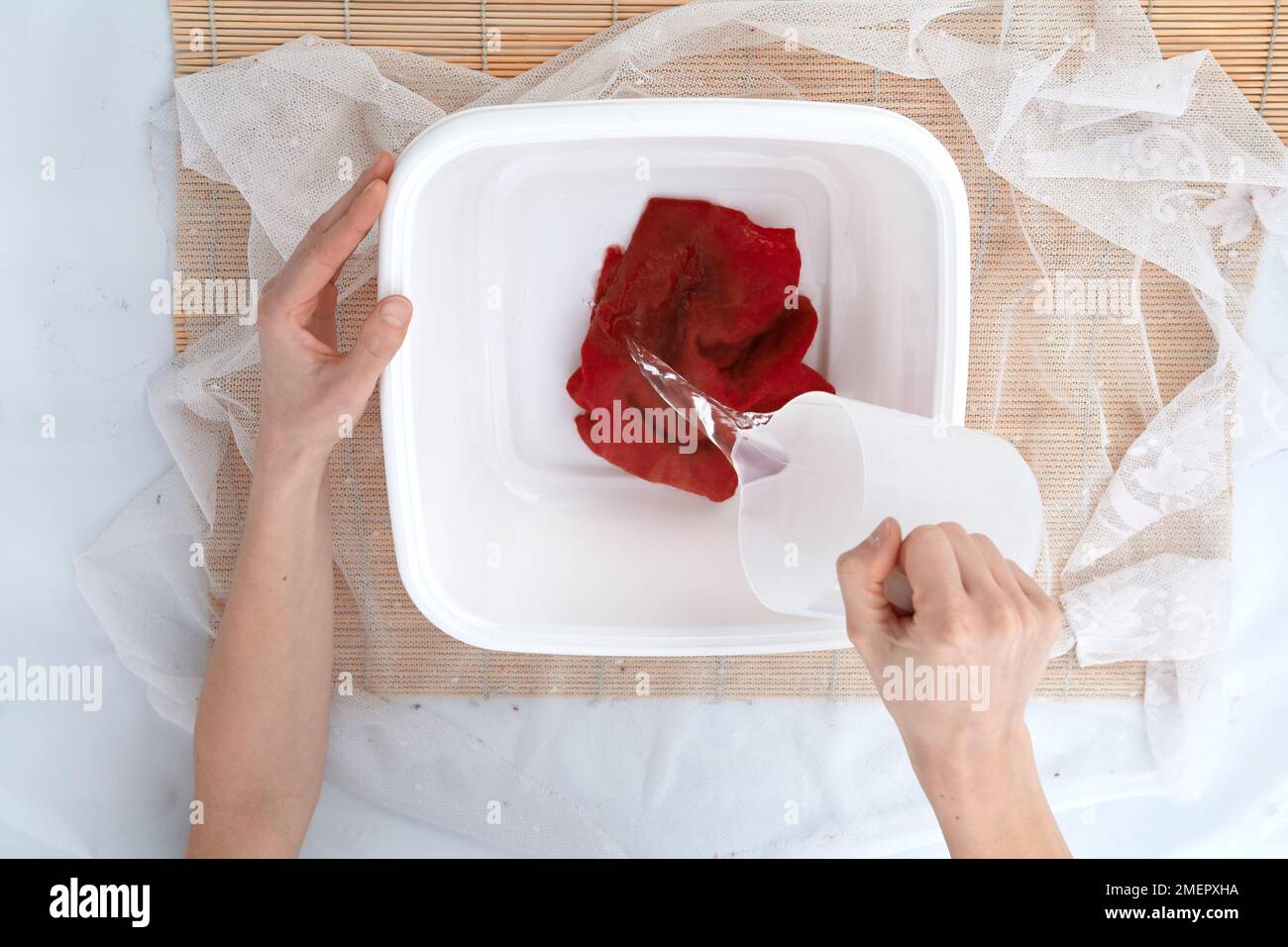 Pouring boiling water over felt in tub, overhead view Stock Photo - Alamy