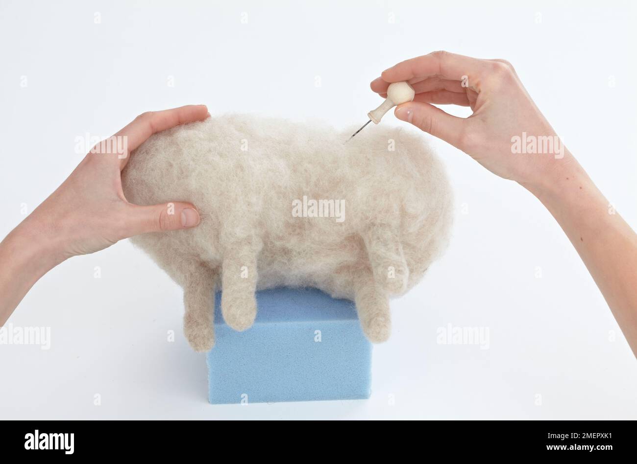 Using felting needle to lightly stab fibres over whole body of needle ...
