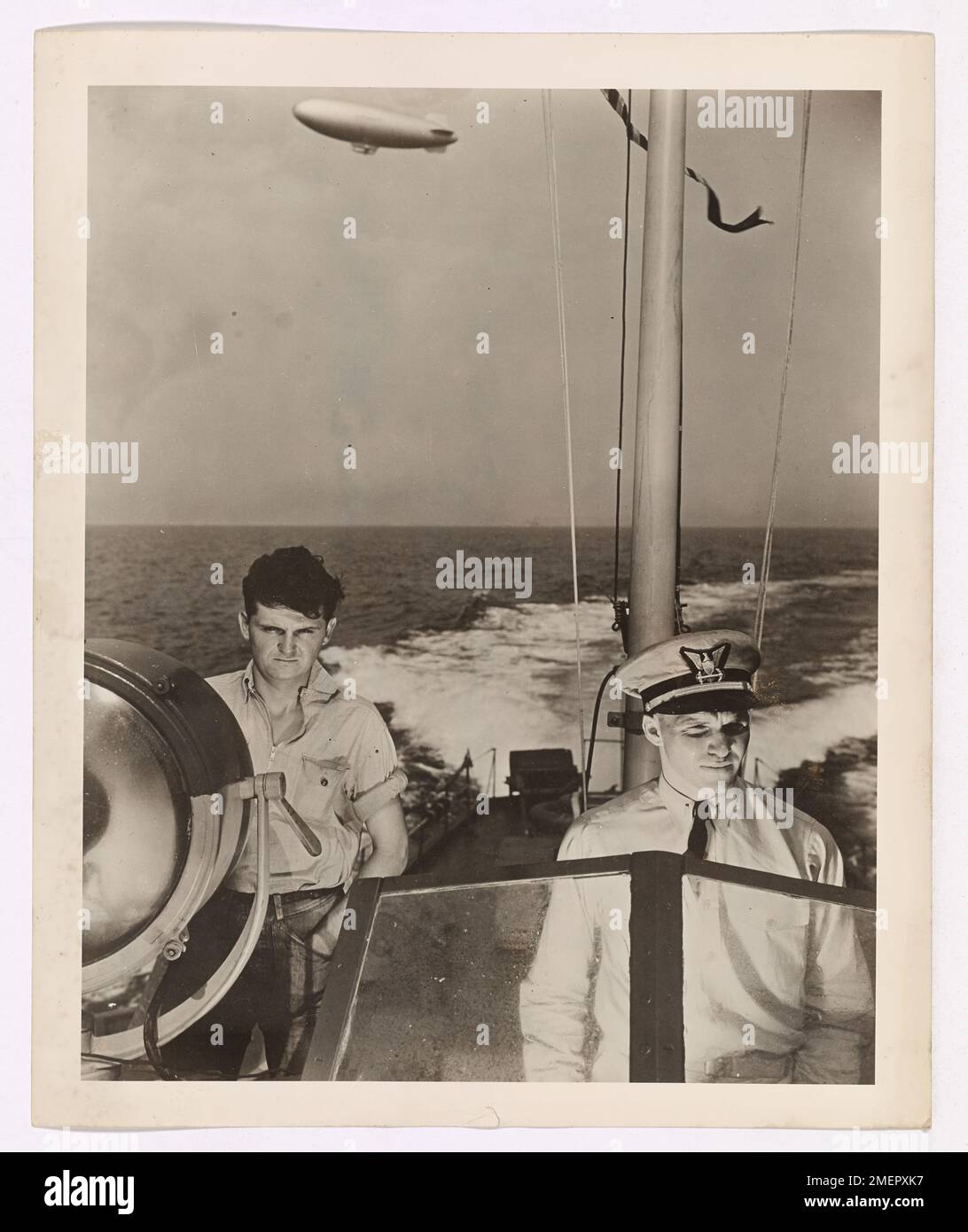 This photograph shows two Coast Guardsmen aboard an 83-foot patrol boat ...