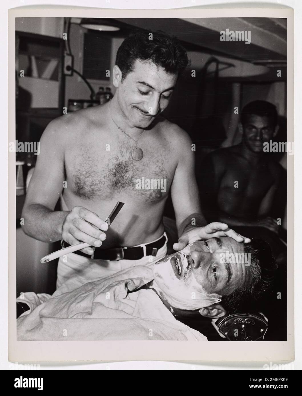 A photograph of actor Cesar Romero with his barber, likely taken during ...