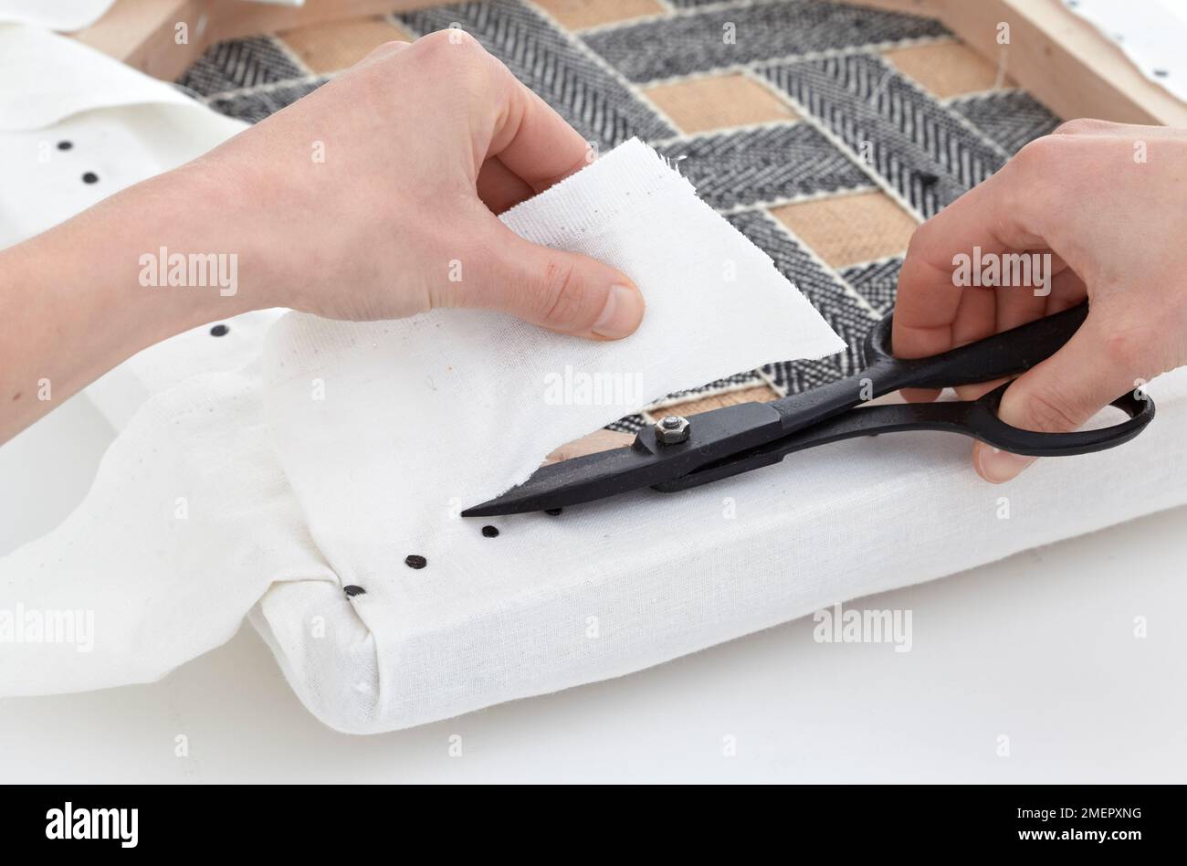 Trimming off excess calico back to the tacks on underside of upholstery ...