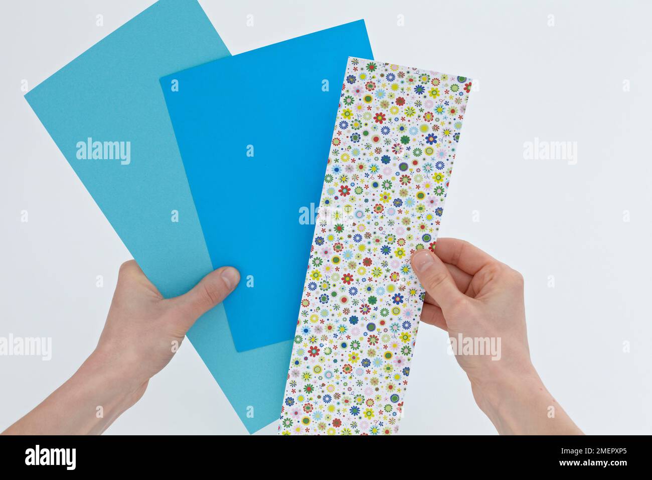 Hands holding three pieces of card used for box making Stock Photo - Alamy