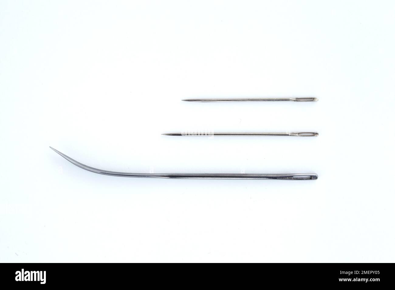 Row of straight and curved upholstery needles, close-up Stock Photo - Alamy