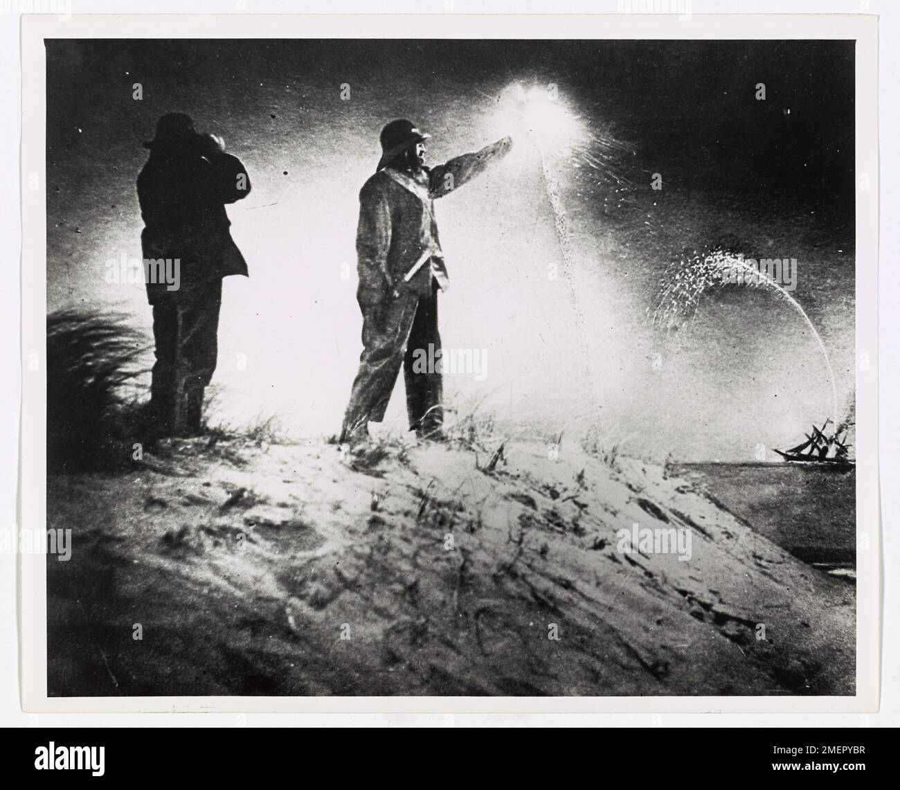 Coast Guardsmen burn Coston signals during a nighttime operation to ...