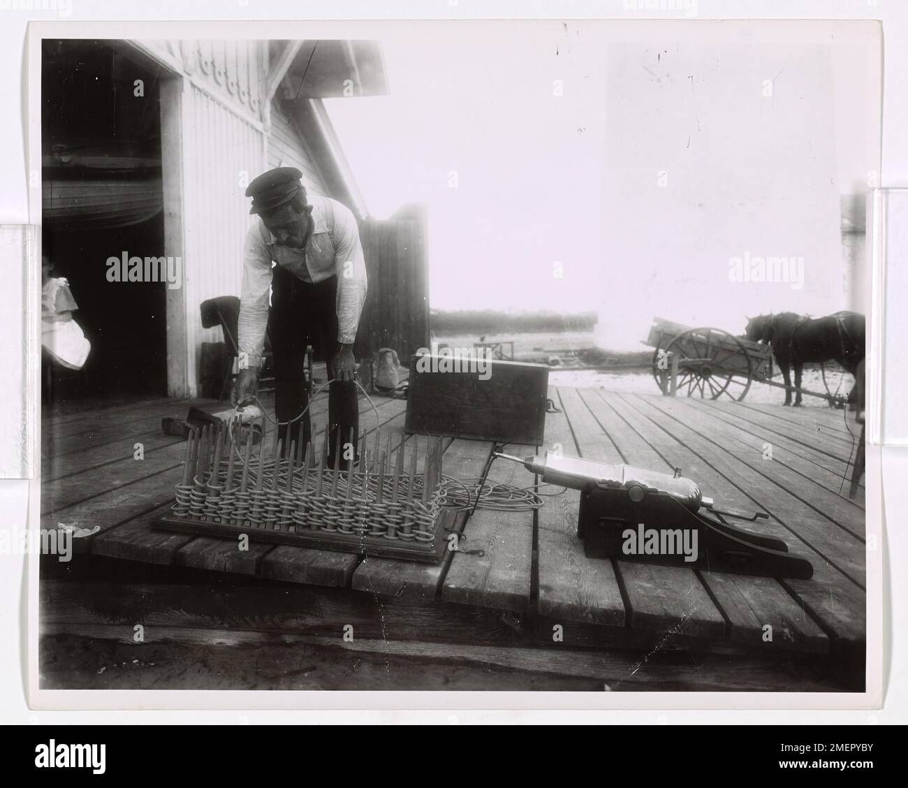This historical photograph shows a crewman at a U.S. Lifesaving Station ...