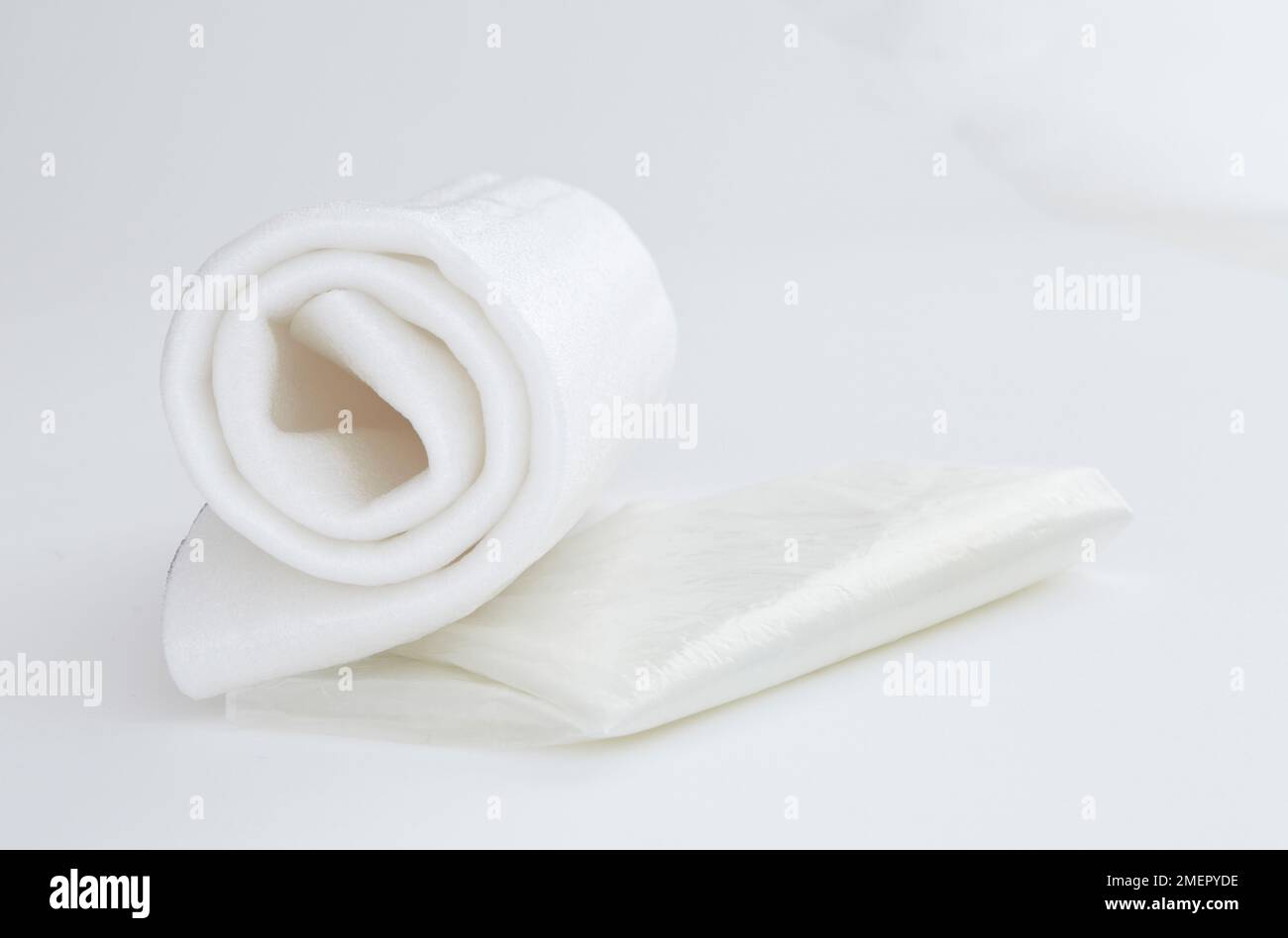 Folded plastic sheeting and rolled-up foam carpet underlay Stock Photo ...