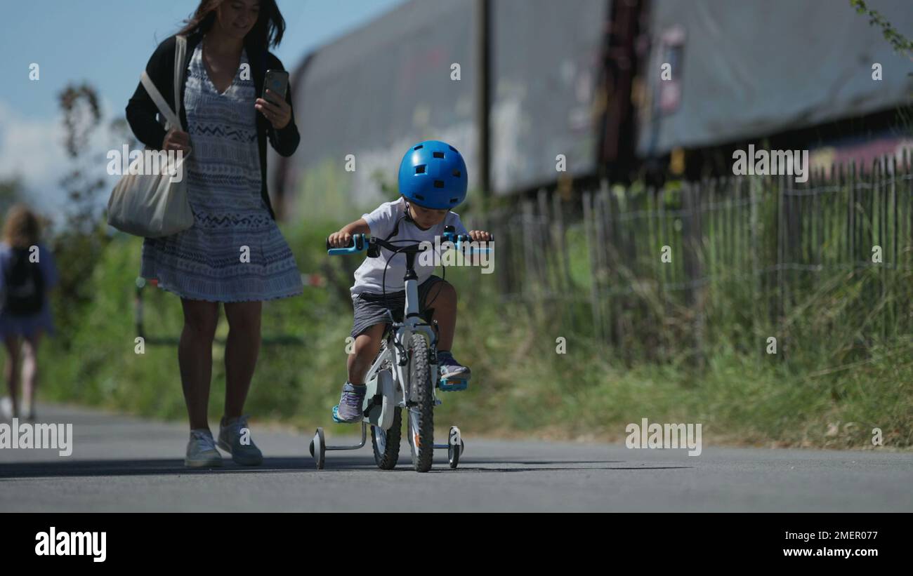 Small boy riding bicycle outside child rides bike wearing helmet Stock ...