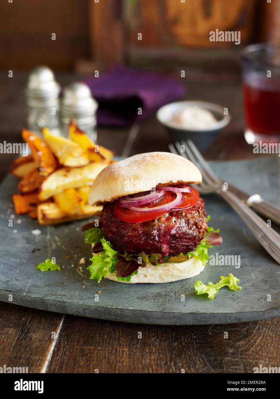 Beef, beetroot and stilton burger in bap, served with veggie chips ...