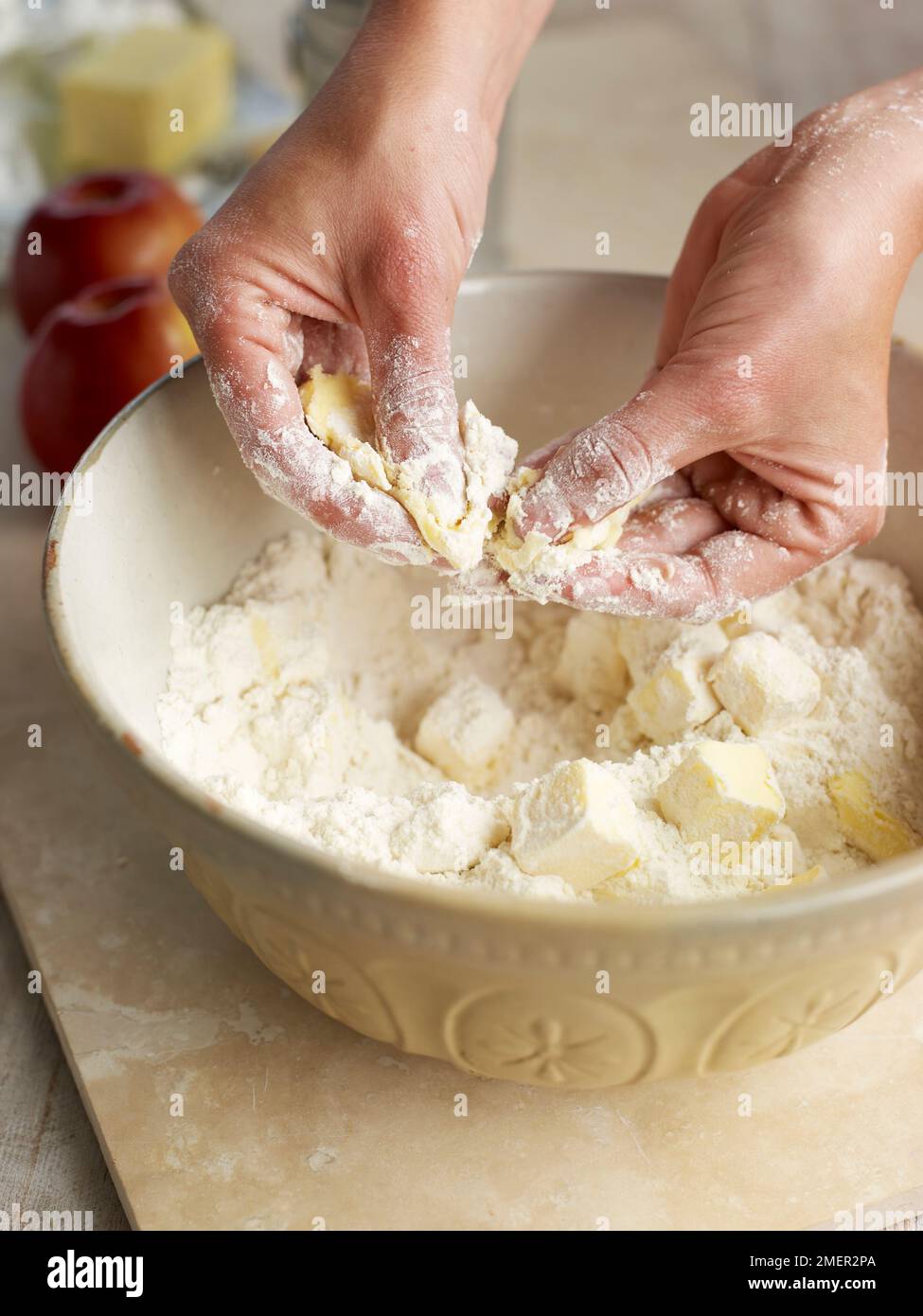 Rubbing butter into flour using fingertips (making pie pastry Stock ...