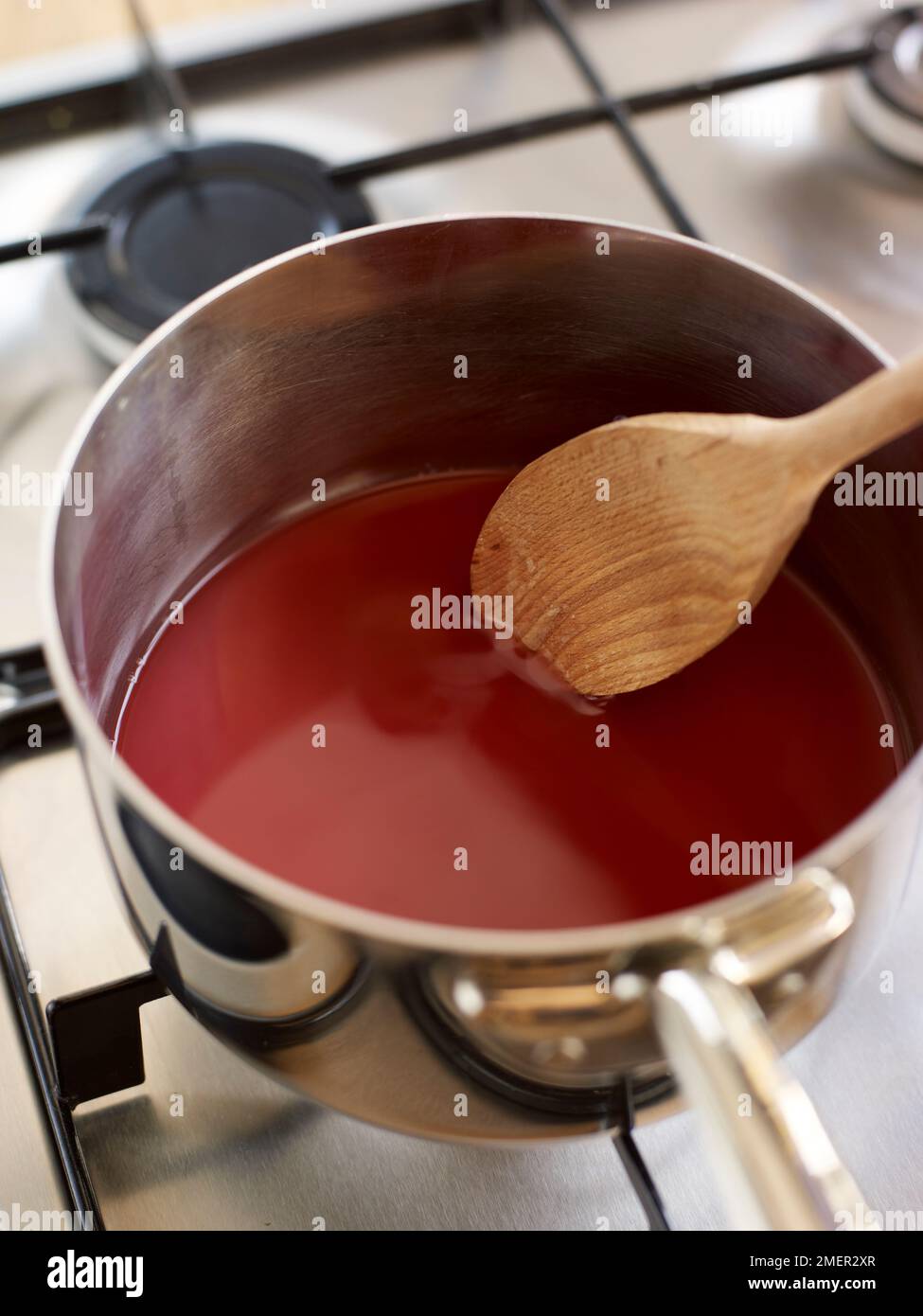 Stirring red sauce in pan with wooden spoon Stock Photo - Alamy