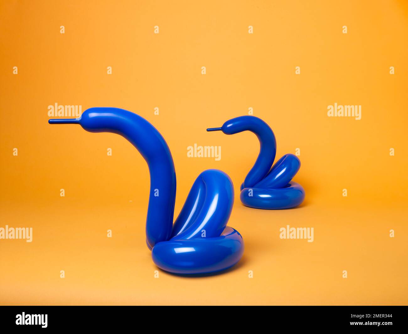 Blue balloon swans on yellow background Stock Photo - Alamy