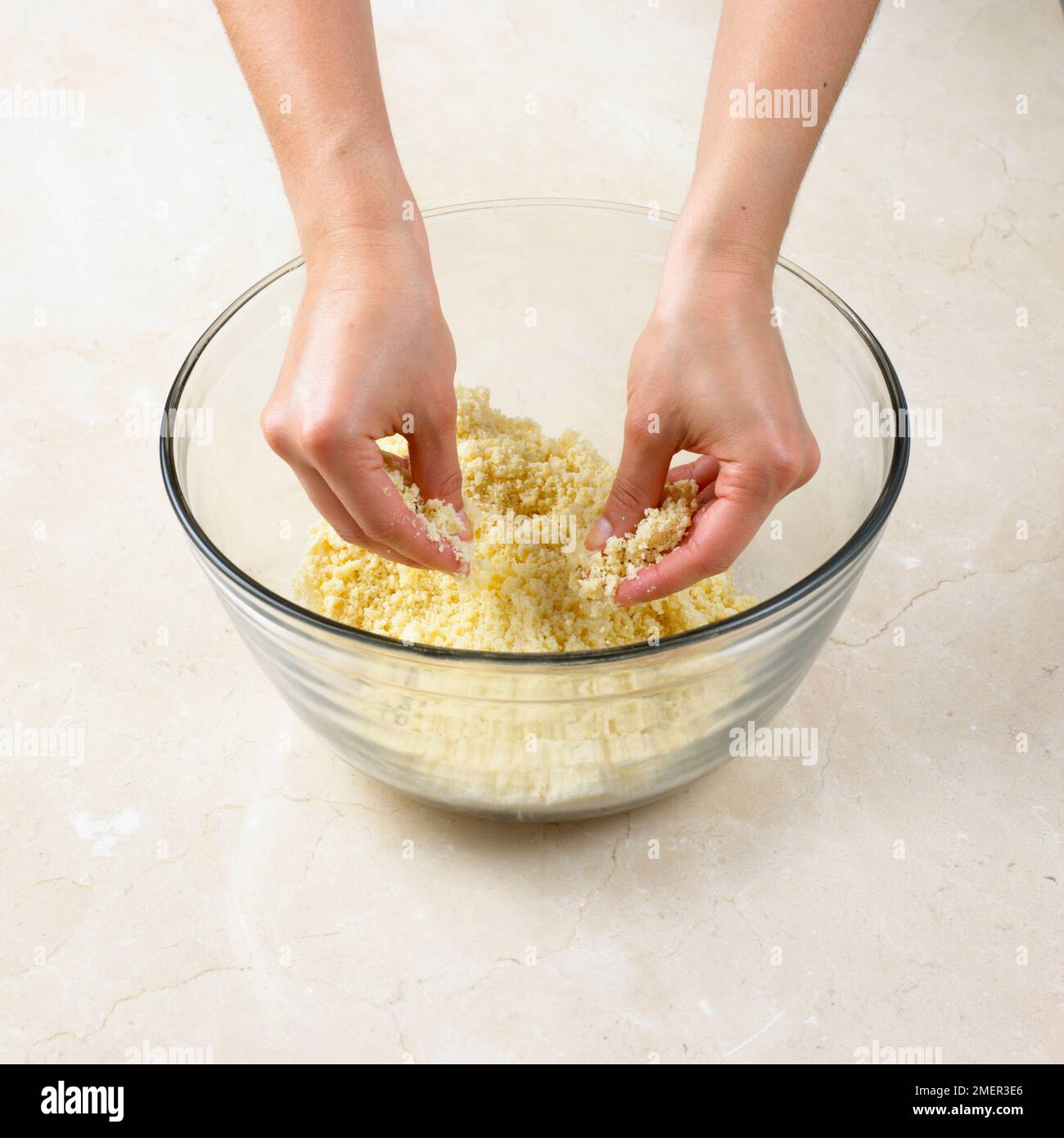 Adding butter crumbs to shortcrust pastry mixture in bowl Stock Photo ...