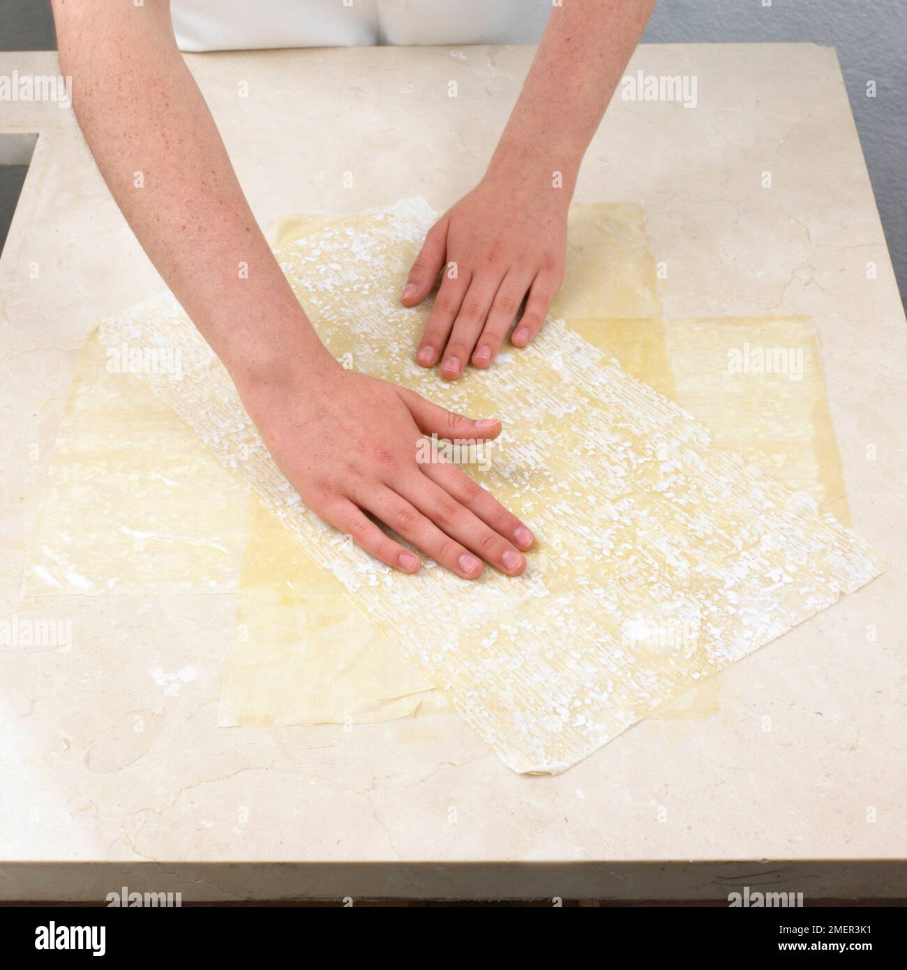 Making a pastilla pastry parcel, layering sheets of filo pastry brushed ...