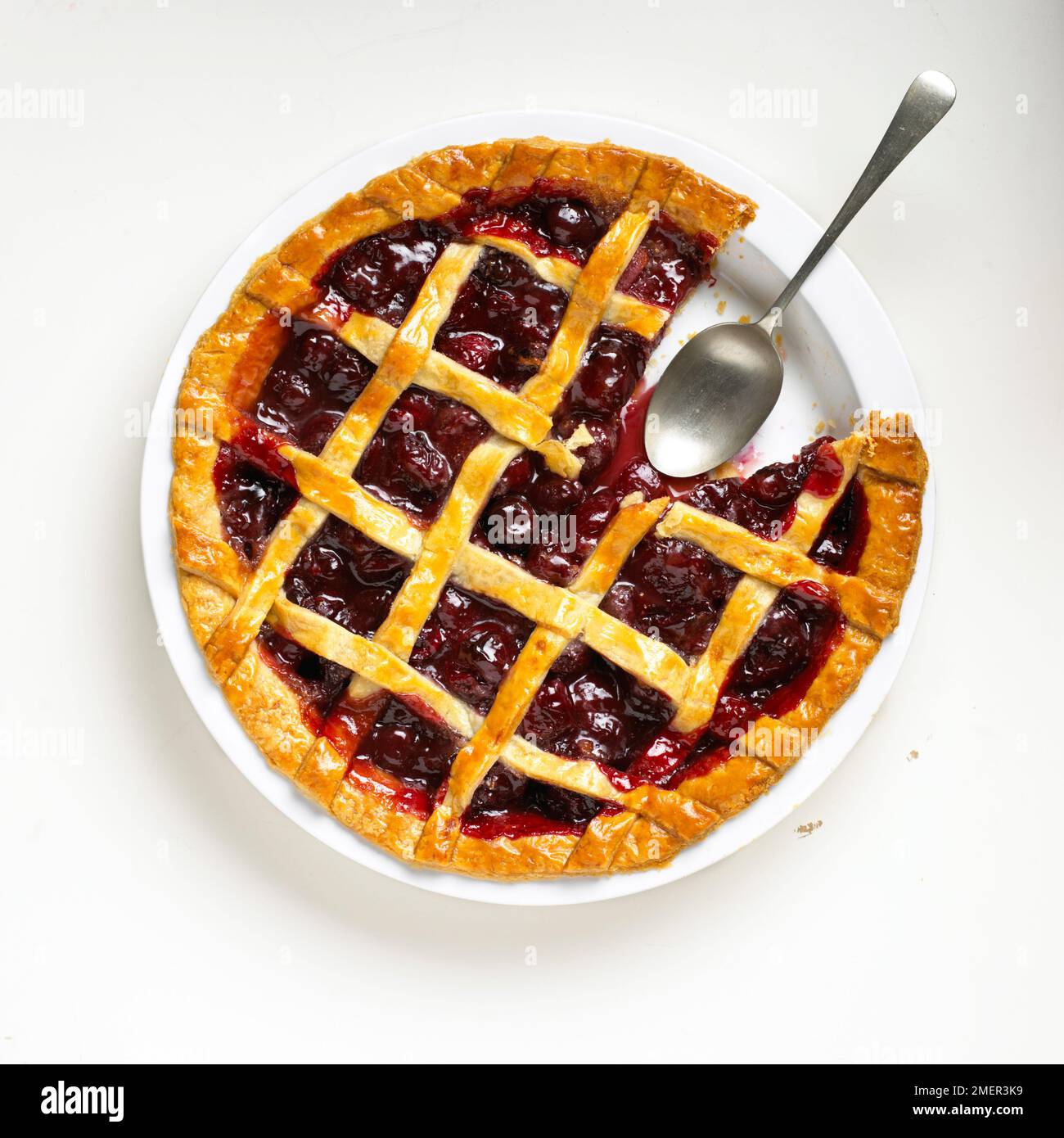Cherry lattice pie with piece missing, and silver spoon Stock Photo - Alamy