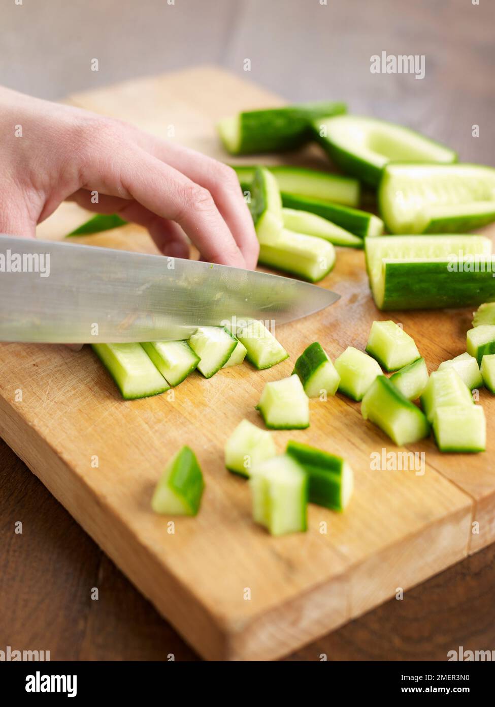 Woman cutting fresh cucumbers hi-res stock photography and images - Alamy