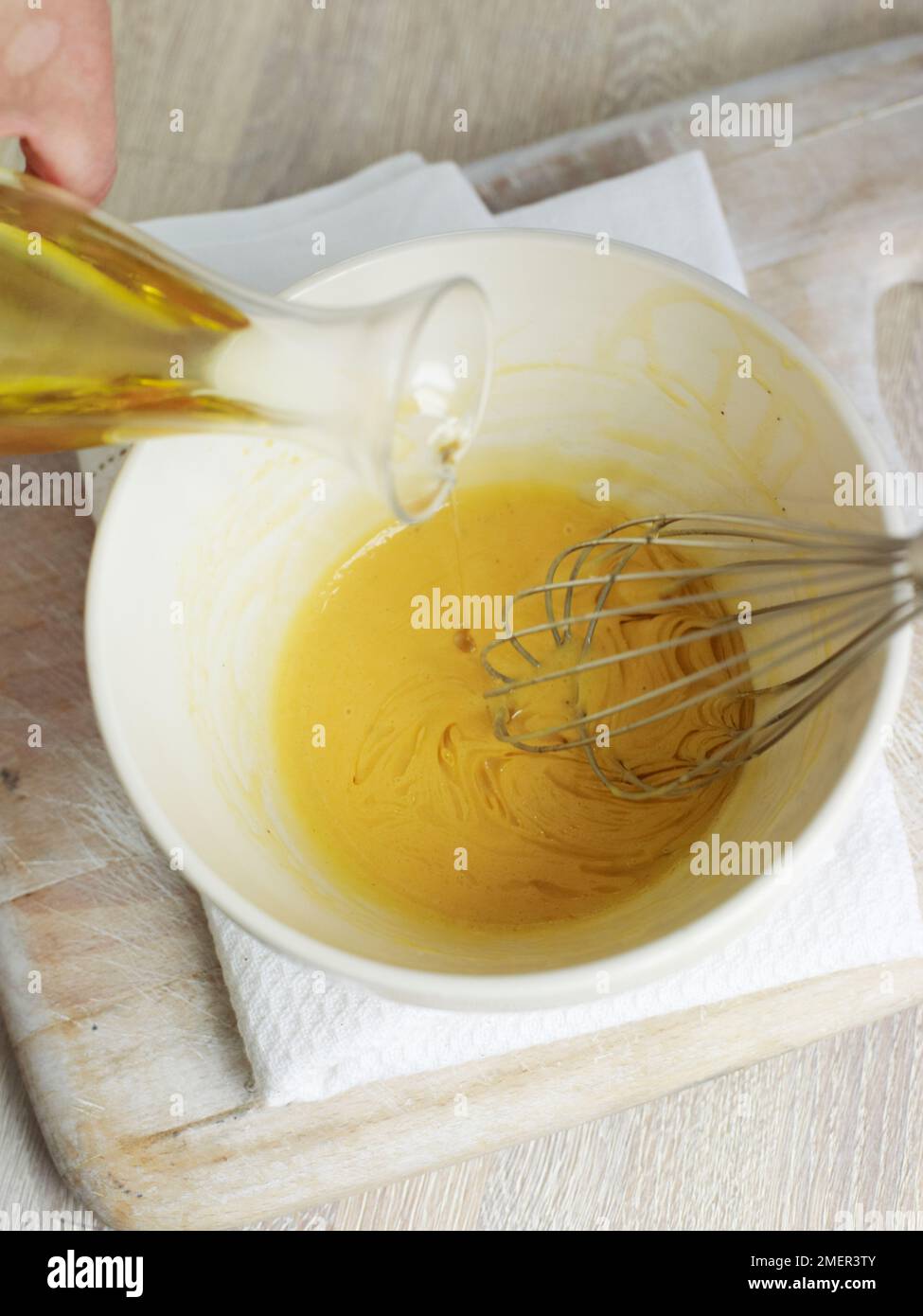 Adding olive oil to egg and mustard mixture (making mayonnaise sauce ...