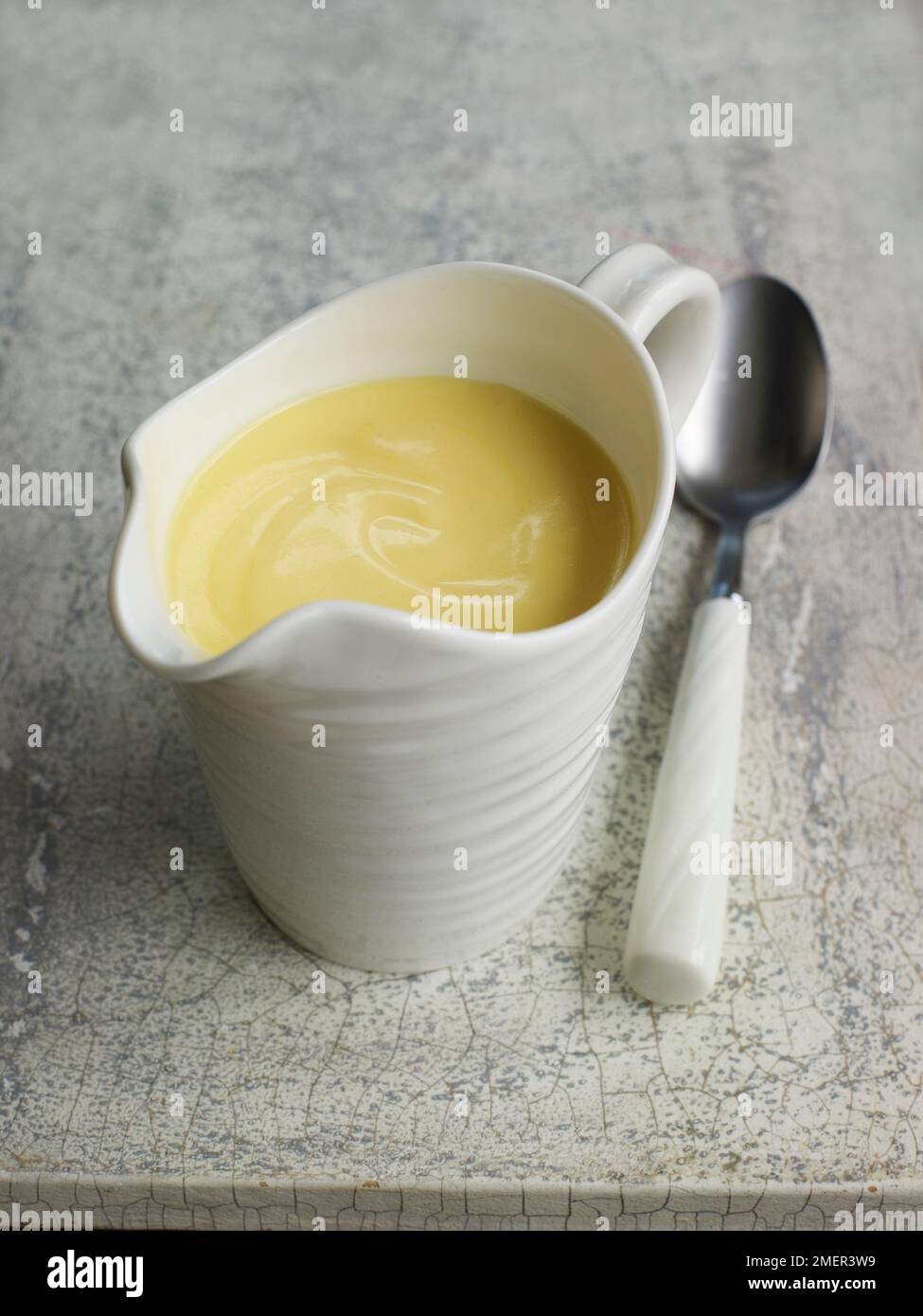 Small jug containing hollandaise sauce Stock Photo - Alamy