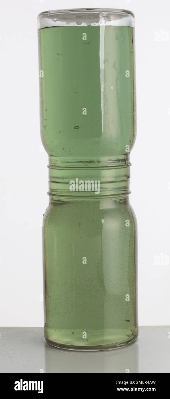 Jar of dirty water upside down on top of another jar Stock Photo - Alamy