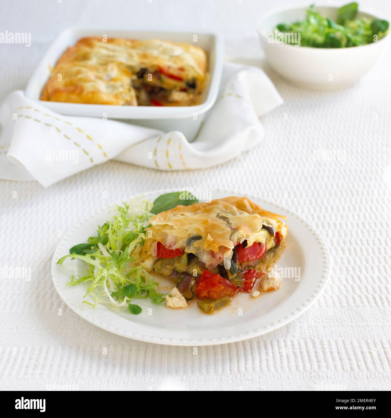 Vegetable feta filo pie on plate with salad garnish Stock Photo - Alamy