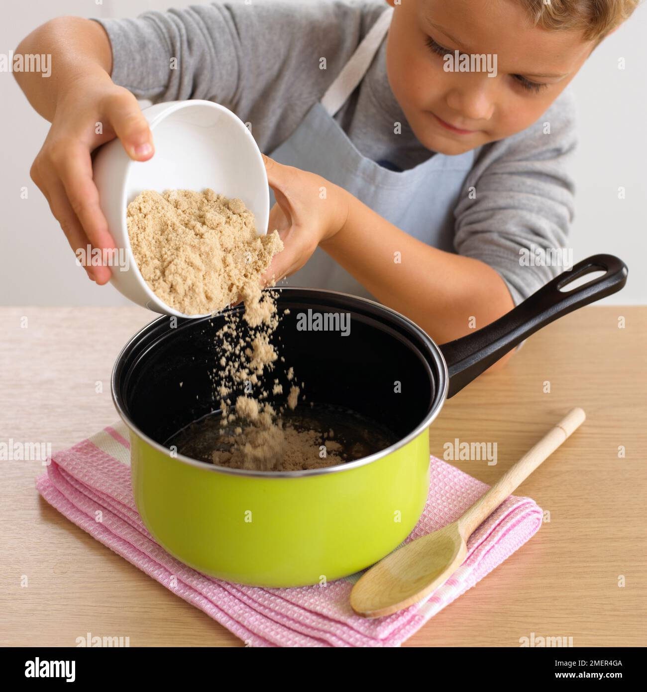 Boy adding sugar to saucepan, 4 years Stock Photo - Alamy
