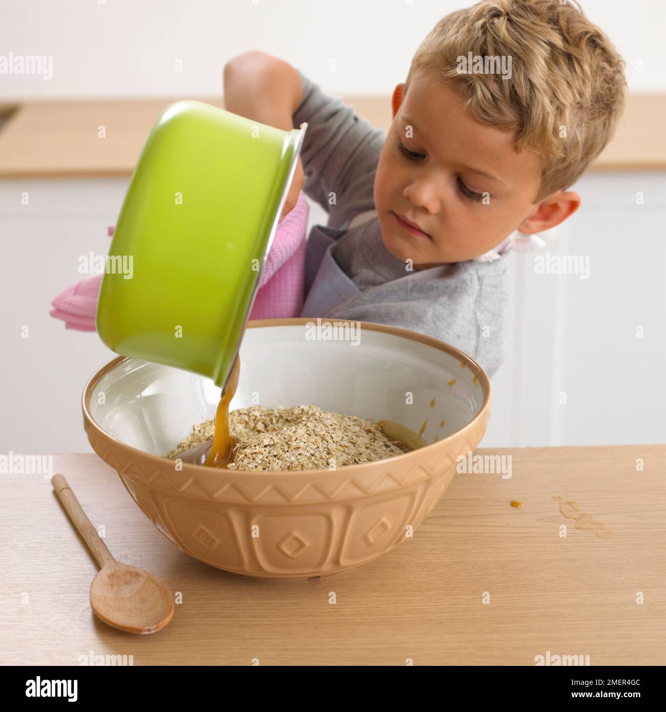 Boy pouring syrup into bowl of porridge oats, 4 years Stock Photo - Alamy