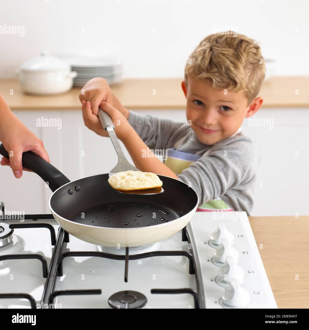 Boy flipping a pancake in a frying pan using a spatula, 4 years Stock ...