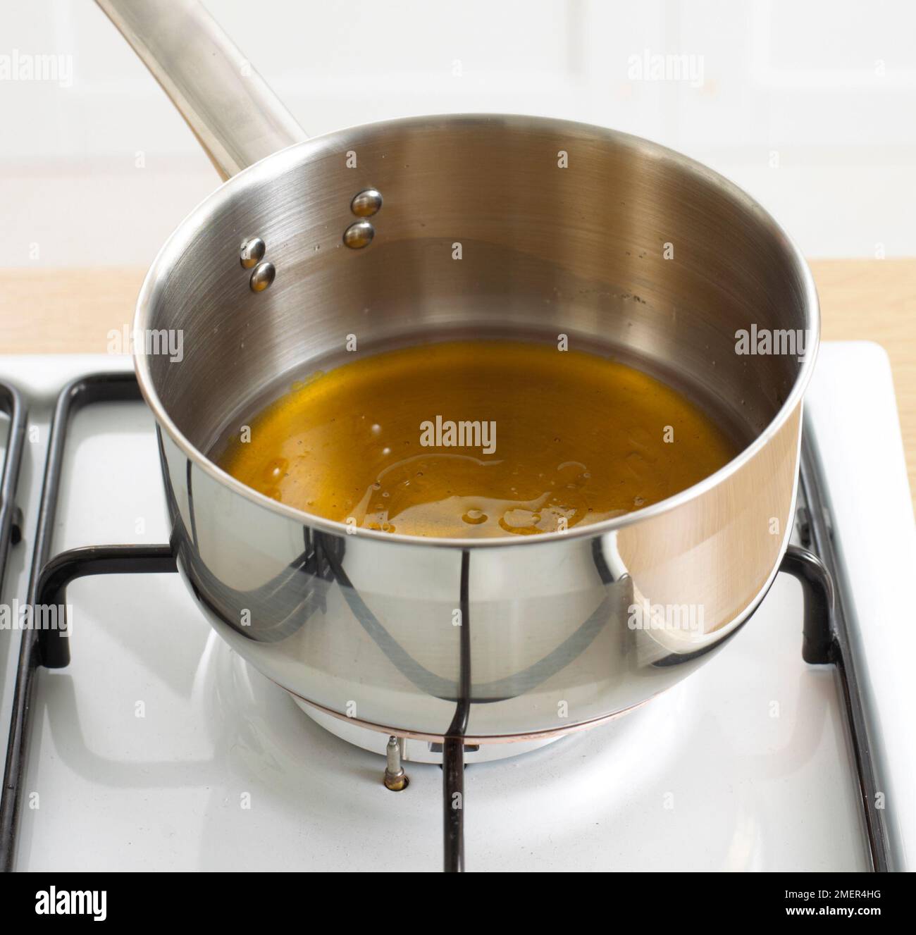 Heating syrup and oil in pan Stock Photo - Alamy