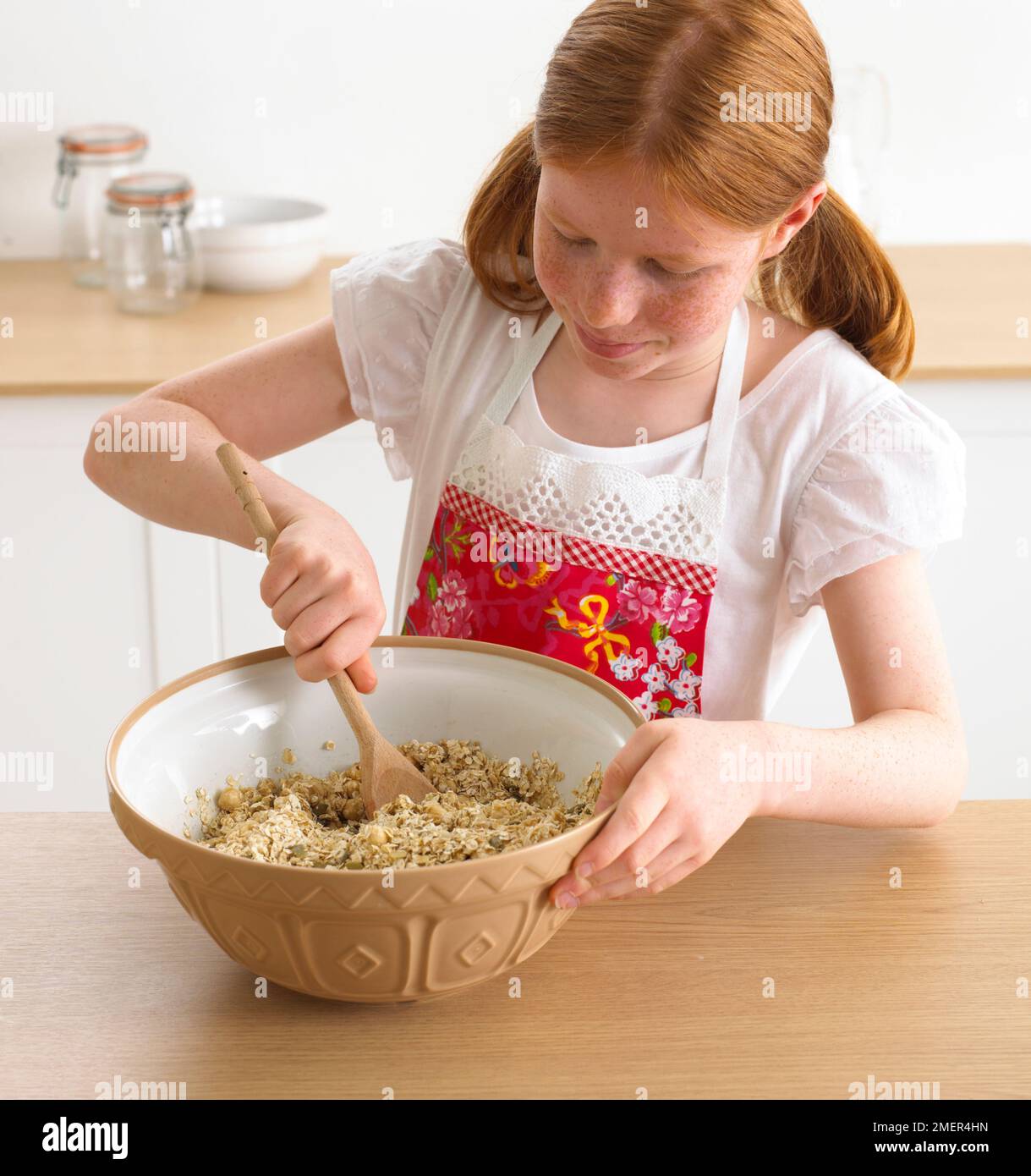 Girl stirring cereal mixture in bowl, 9 years Stock Photo - Alamy