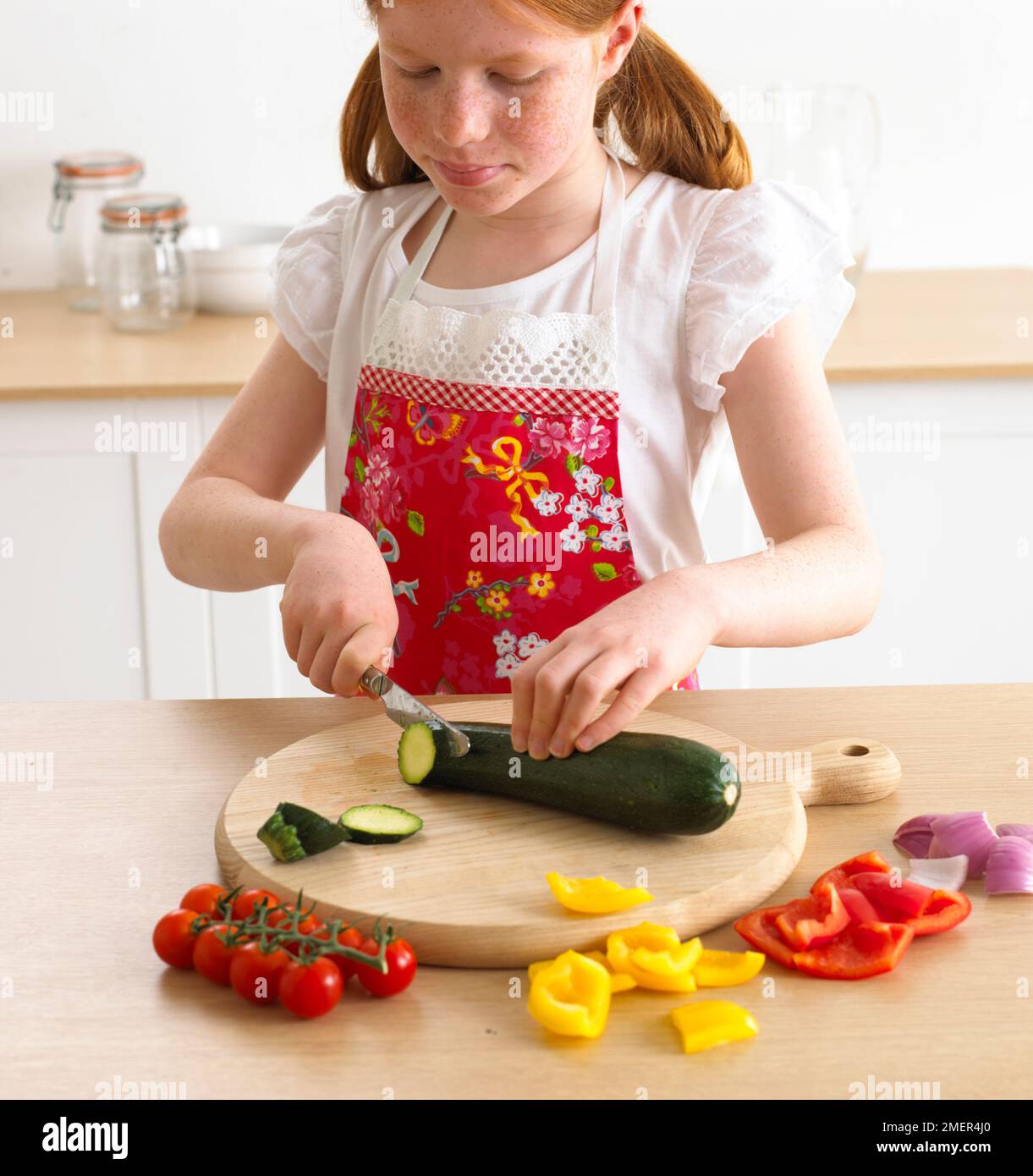 Girl chopping courgette, peppers and tomatoes, 9 years Stock Photo - Alamy