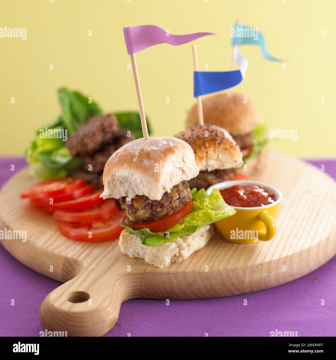 Mini burgers with flag skewers, sliced tomatoes and mini cup of tomato ...