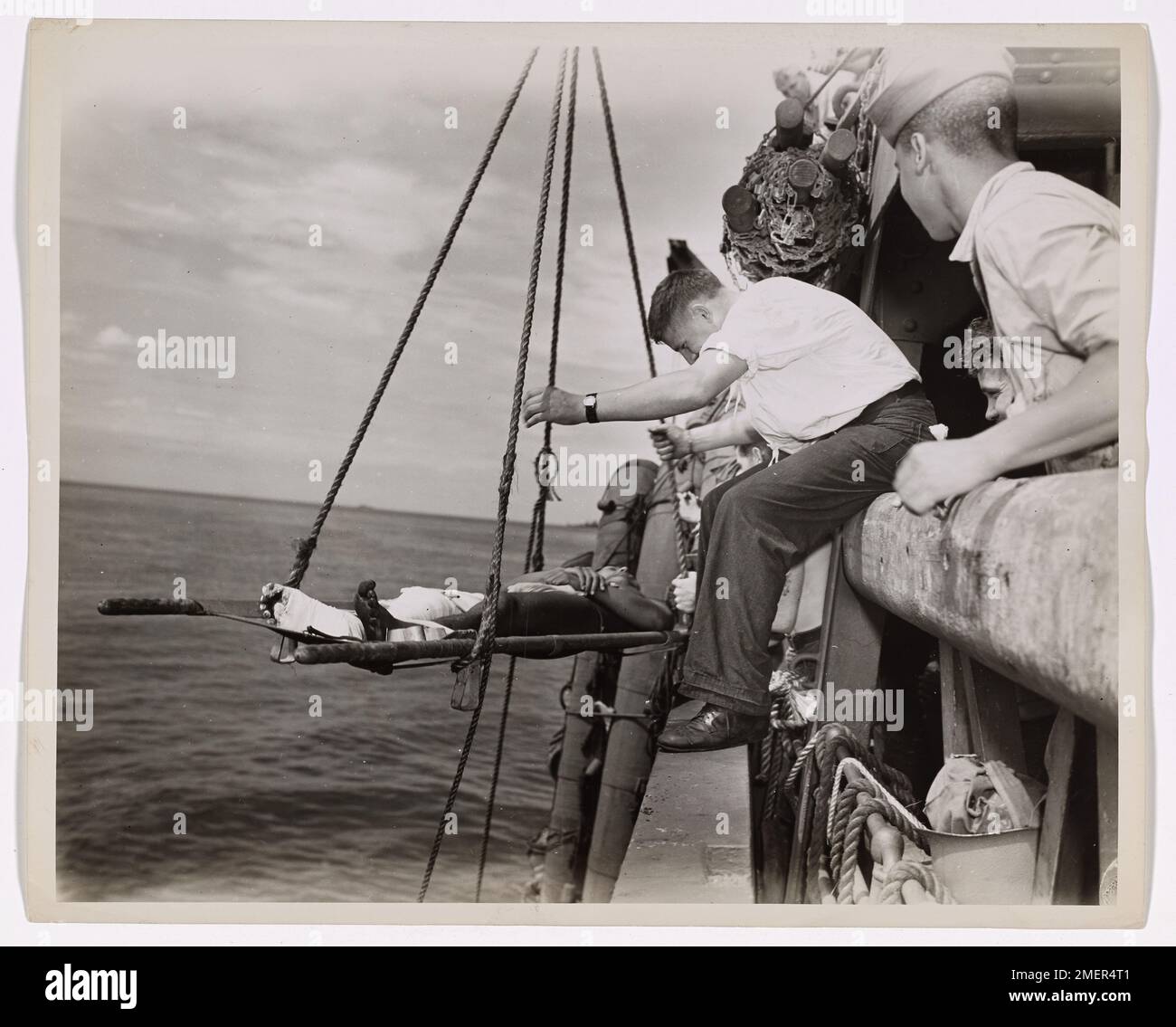 U.S. Coast Guardsmen assist a wounded Japanese prisoner aboard their ...