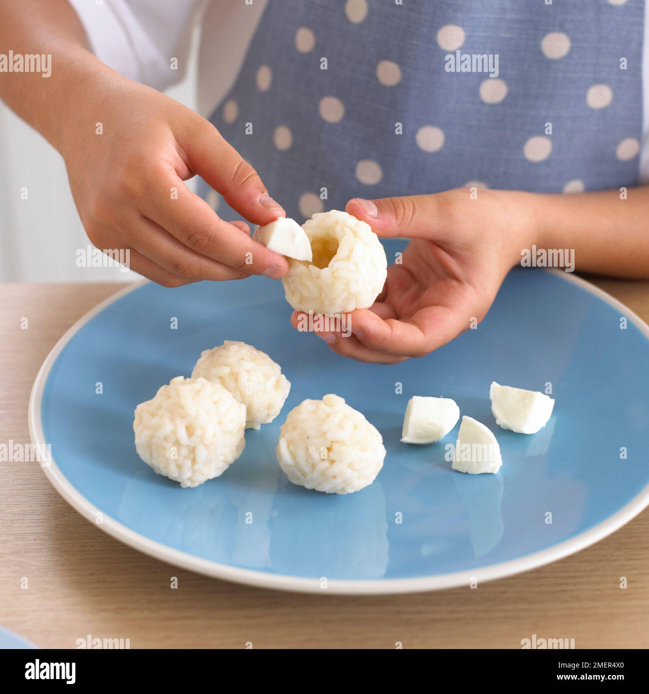 Inserting mozzarella into ball of rice Stock Photo - Alamy