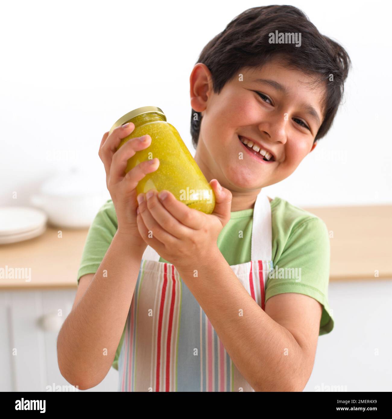 Boy shaking jar of salad dressing, 9 years Stock Photo - Alamy
