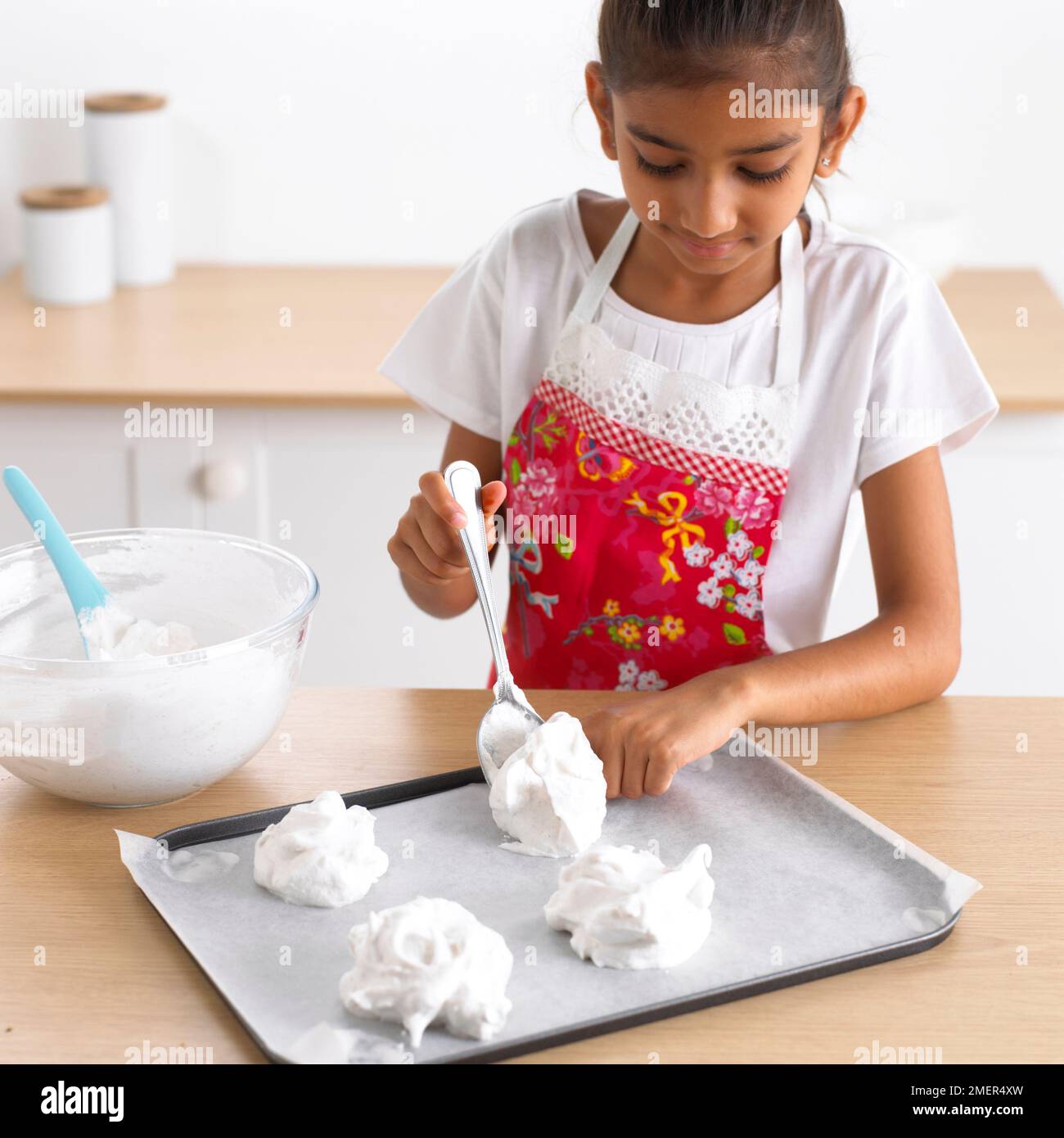 Spooning uncooked meringue onto baking tray, 8 years Stock Photo - Alamy