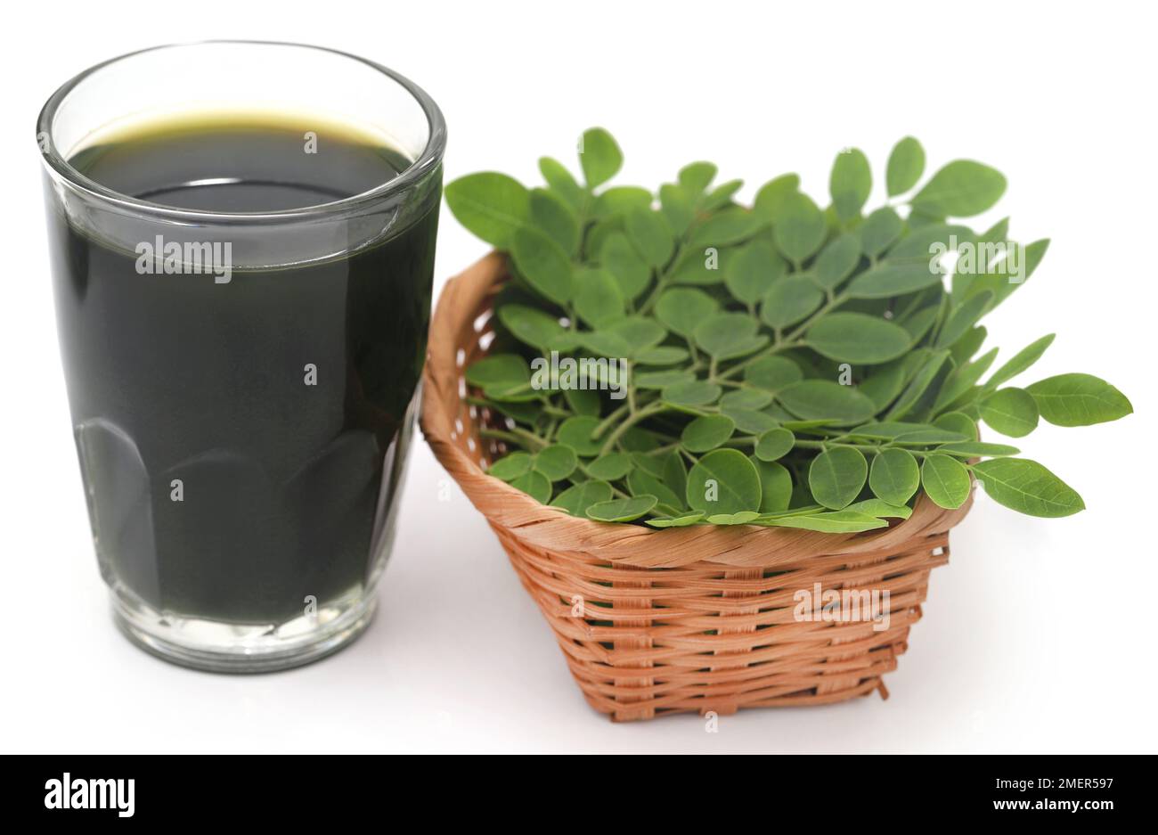 Moringa leaves with extract in a glass over white background Stock ...